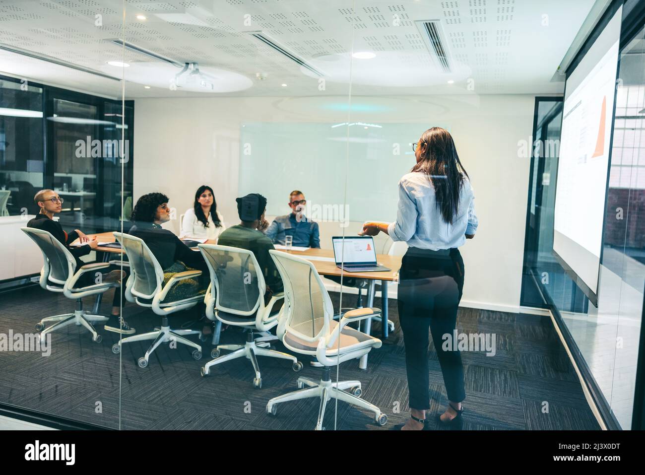 businesswoman giving a presentation to her colleagues in a modern ...