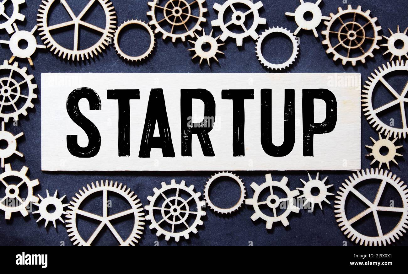 startup word written on wood block. startup text on table, concept ...