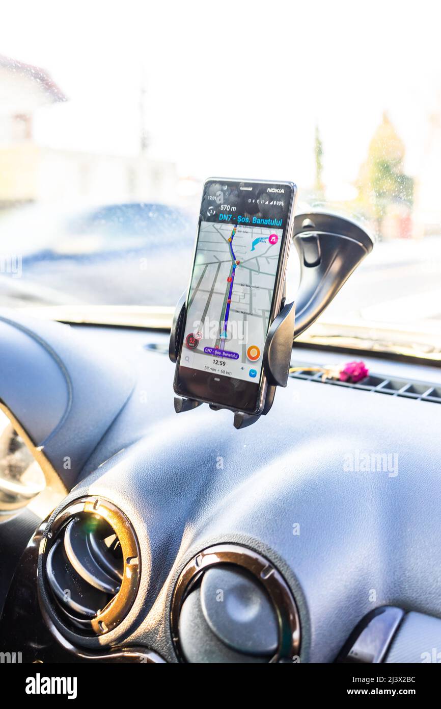 Using waze maps application on smartphone in car dashboard. Driver ...