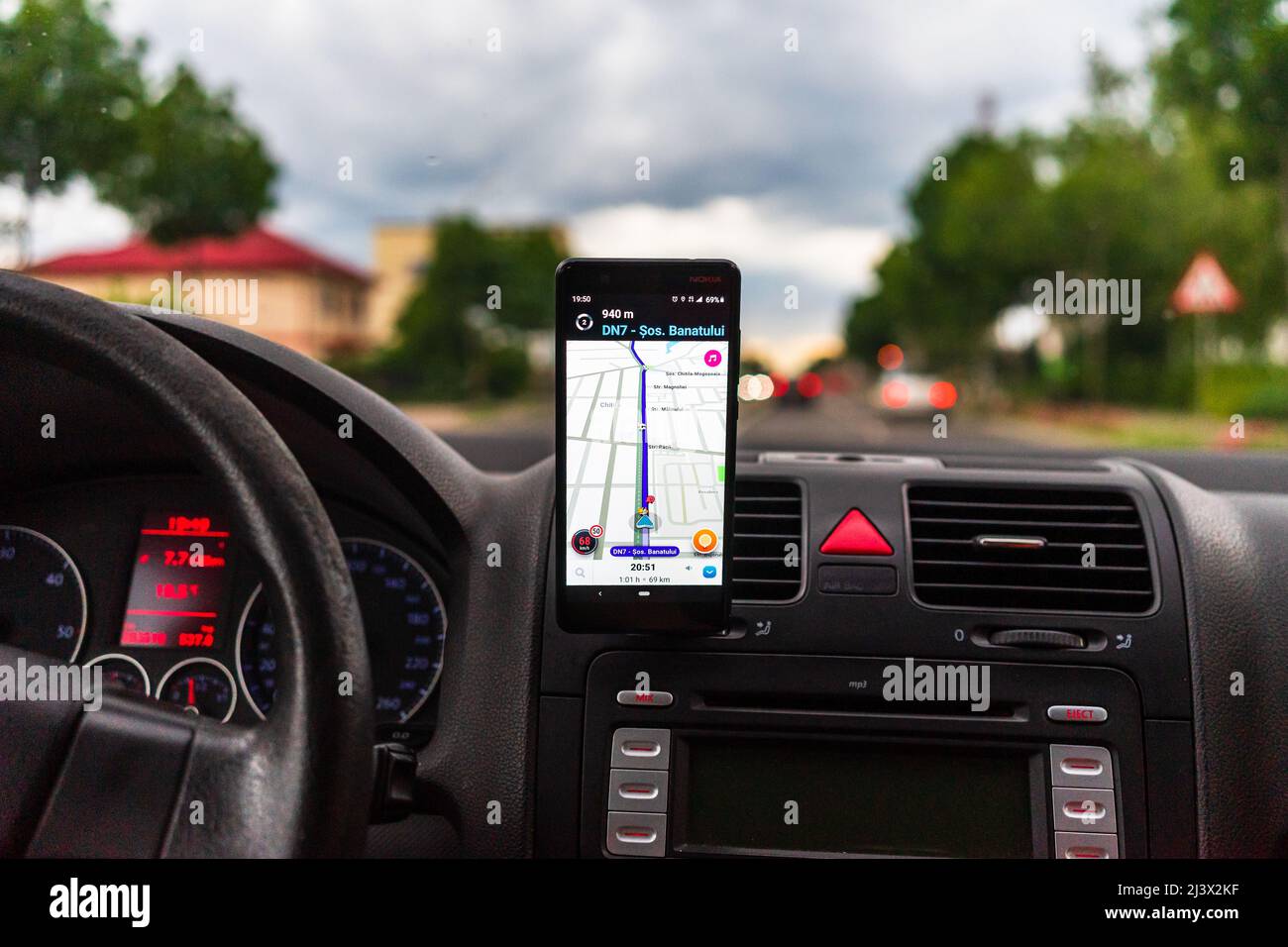 Driving and using waze maps application on smartphone on car dashboard ...