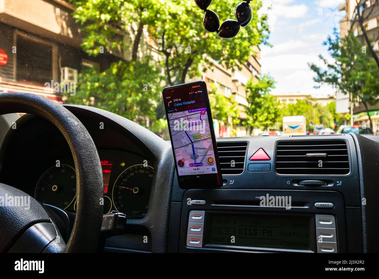 In car dashboard view with smartphone showing Waze maps to show the way ...