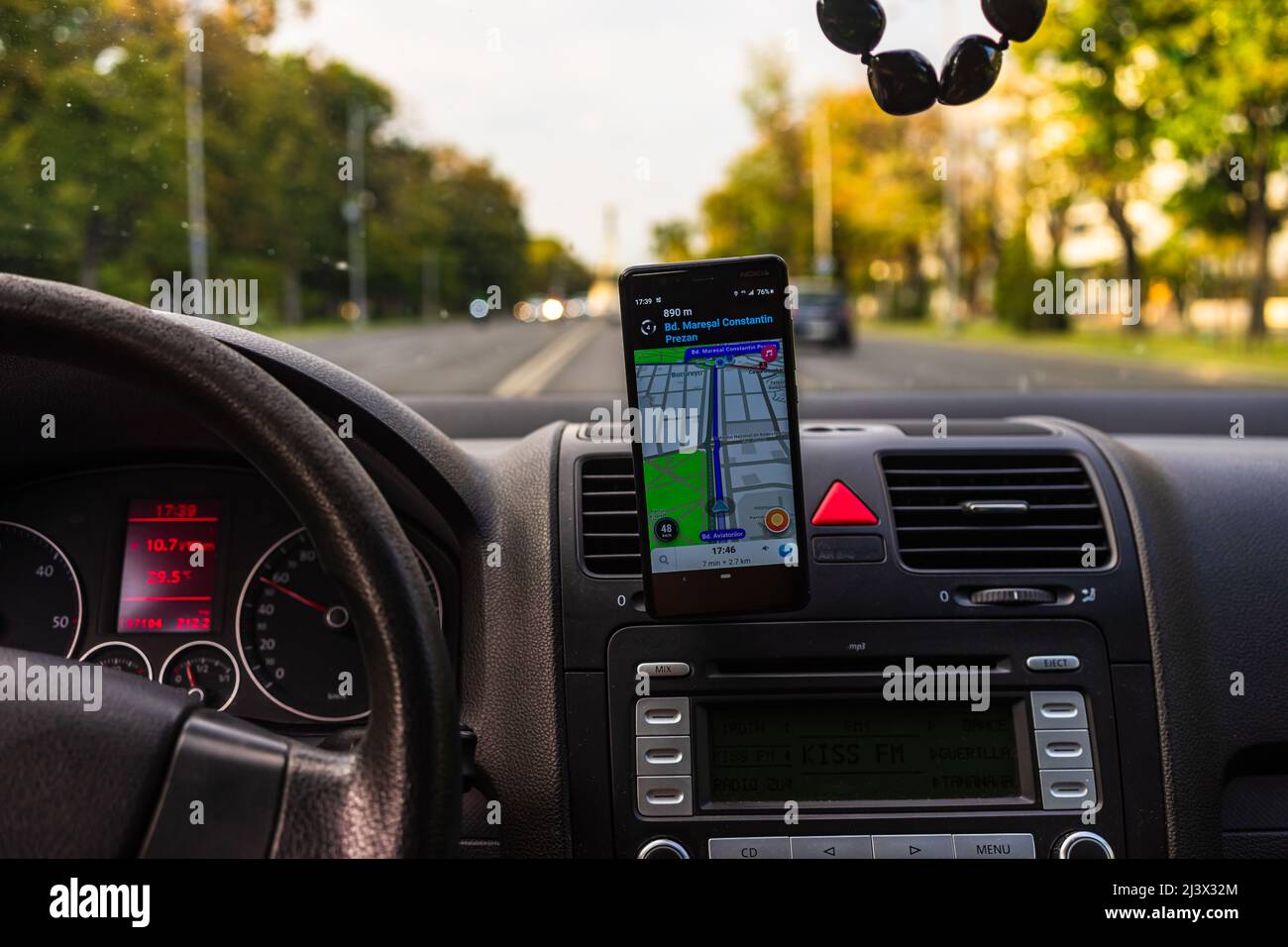 In car dashboard view with smartphone showing Waze maps to show the way ...