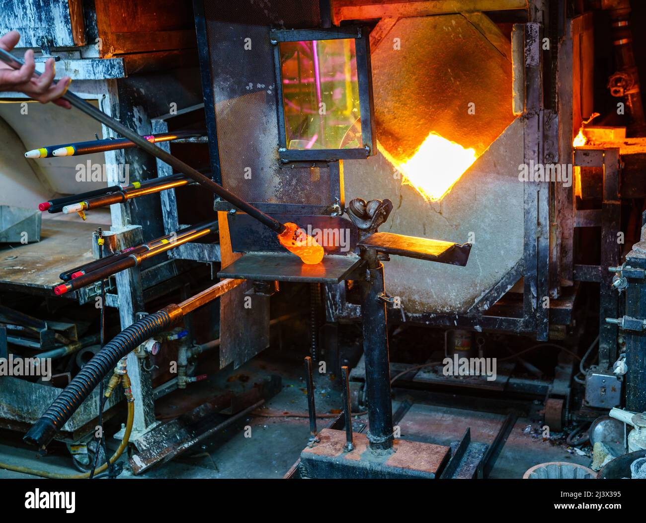 Shaping the hot glass gather during glassblowing process Stock Photo ...