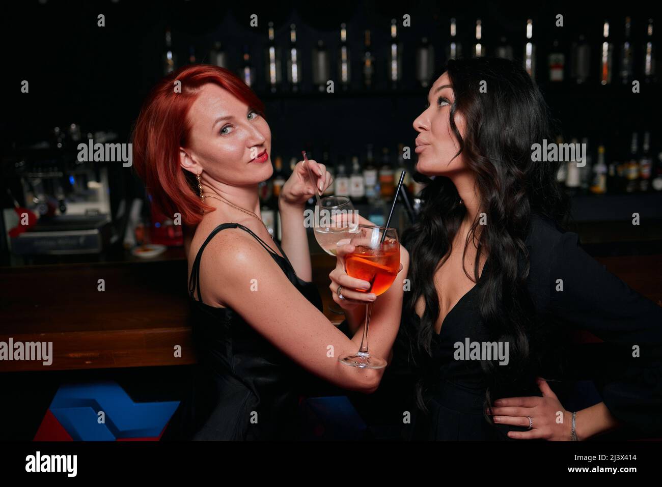 Two Young Women Having Fun In Busy Bar Stock Photo - Alamy
