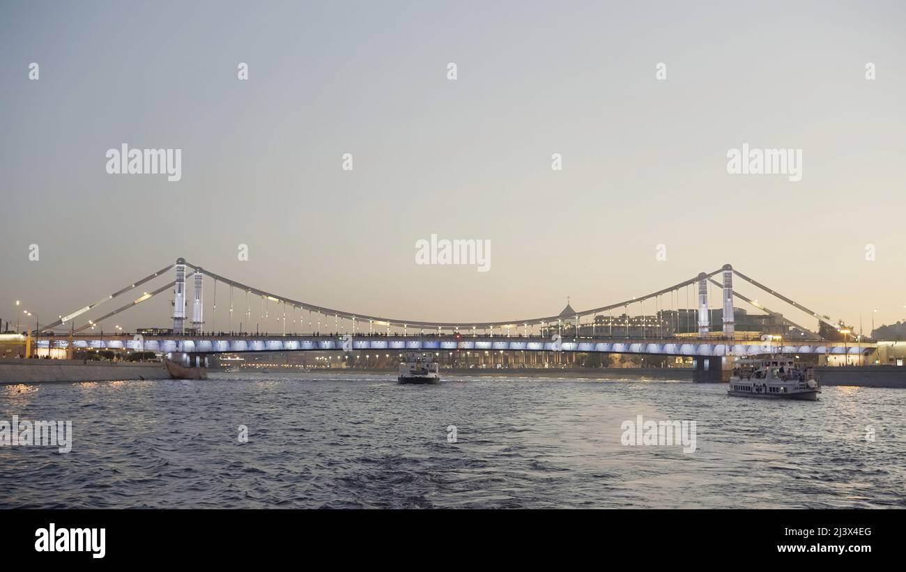 Beautiful rippling river crossed by the bridge decorated by lights ...