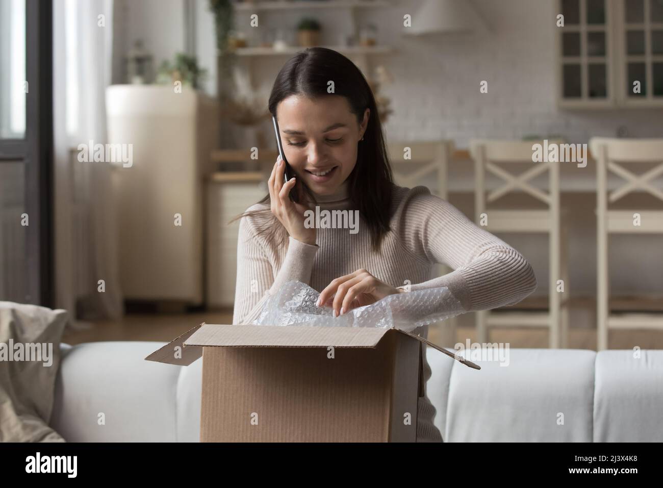 Happy parcel receiver girl opening box, unwrapping parcel Stock Photo ...