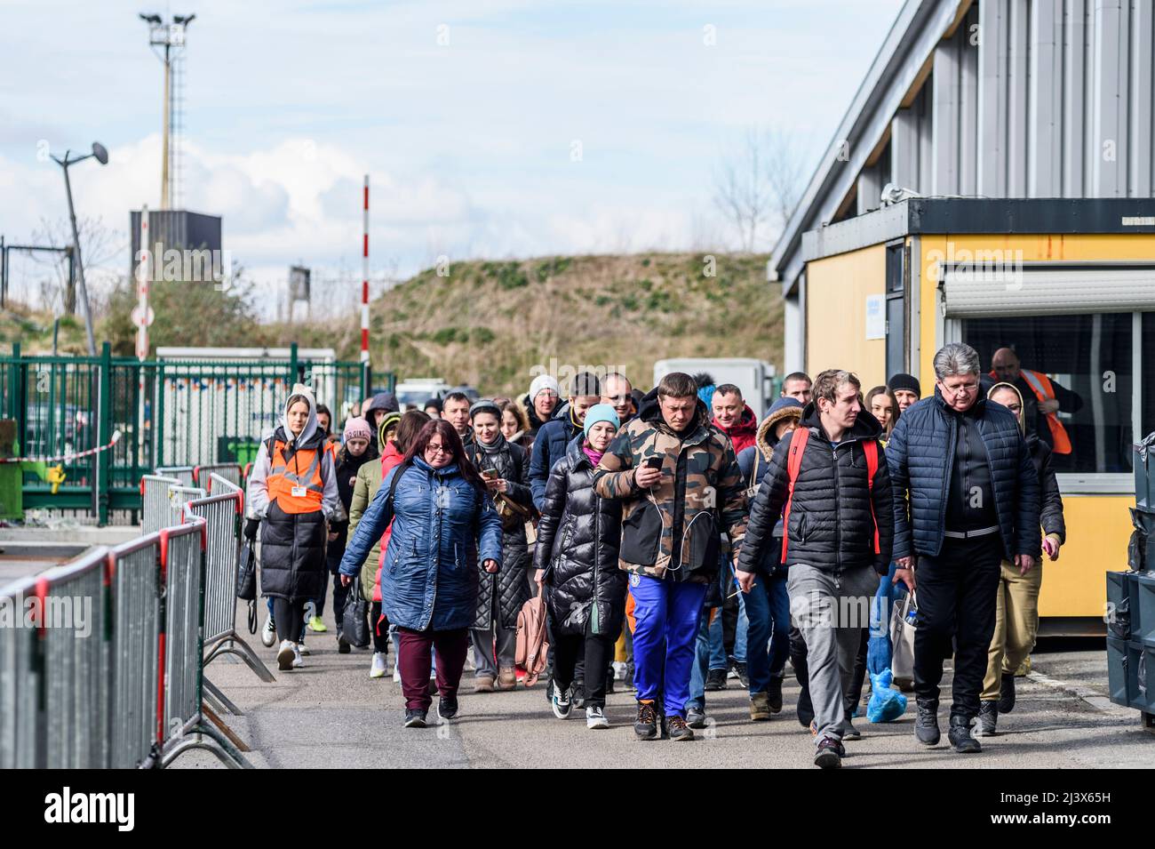 Family, women and men and children wait at the main entrance of the ...