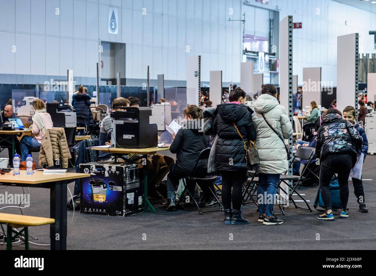 Family, women and men and children wait at the main entrance of the ...