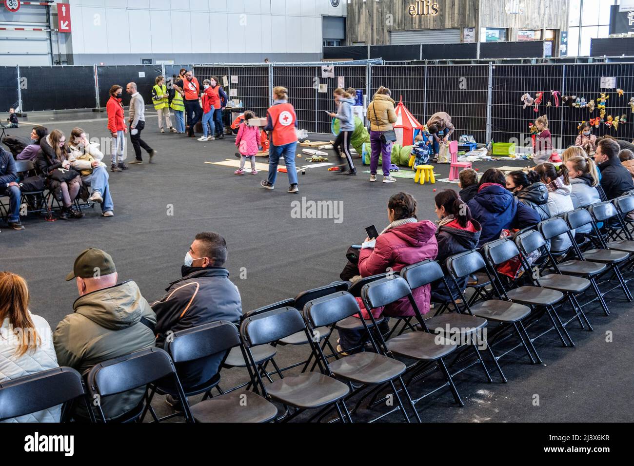 Family, women and men and children wait at the main entrance of the ...
