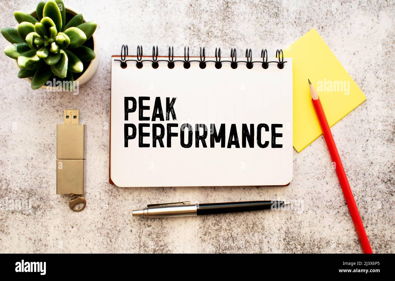 businesman hold notepad with text PEAK PERFORMANCE. White background ...
