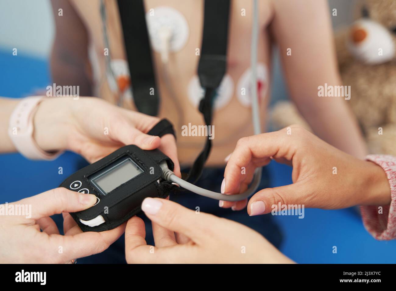 Doctor showing ECG holter monitor to patient in pediatric clinic Stock ...