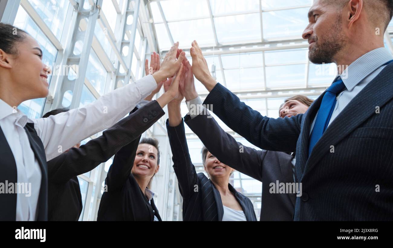 Happy successful multiracial business team giving a high fives gesture ...