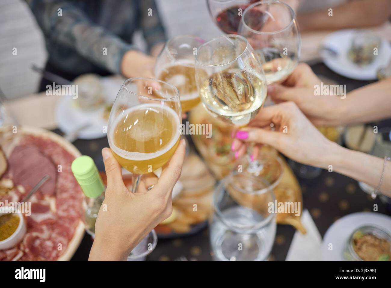 Celebrating with glasses of alcohol in hands. Happy female friends ...