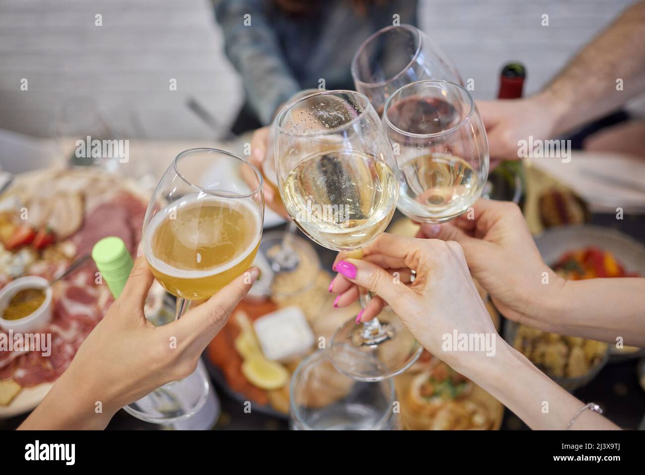 Celebrating with glasses of alcohol in hands. Happy female friends ...
