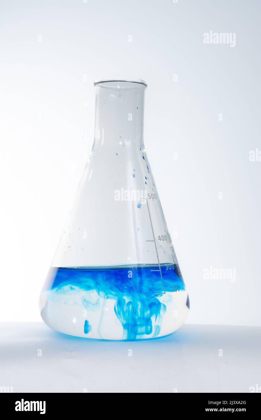 Graduated Erlenmeyer glass flask with blue liquid Stock Photo - Alamy