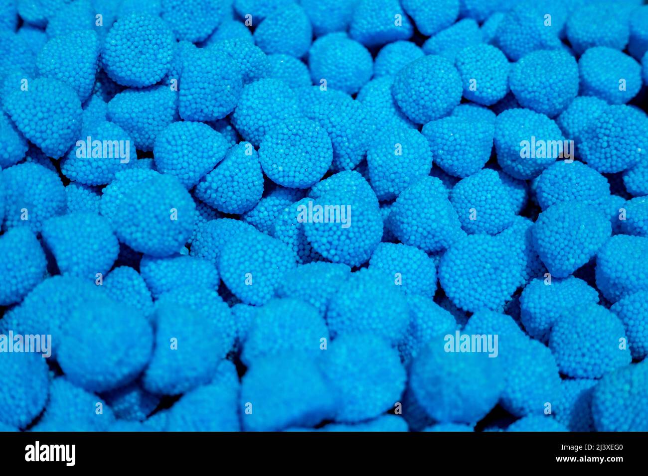 A scattering of blue raspberry-shaped chocolates Stock Photo - Alamy
