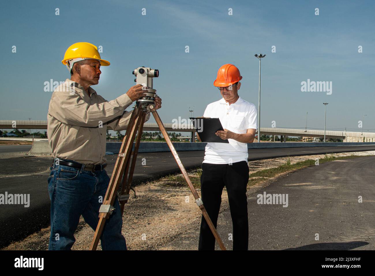 Engineer or surveyor working with theodolite equipment at road construction site Stock Photo - Alamy