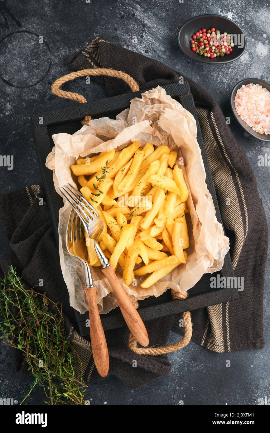 French fries. Tasty French fries server on parchment paper on wooden ...