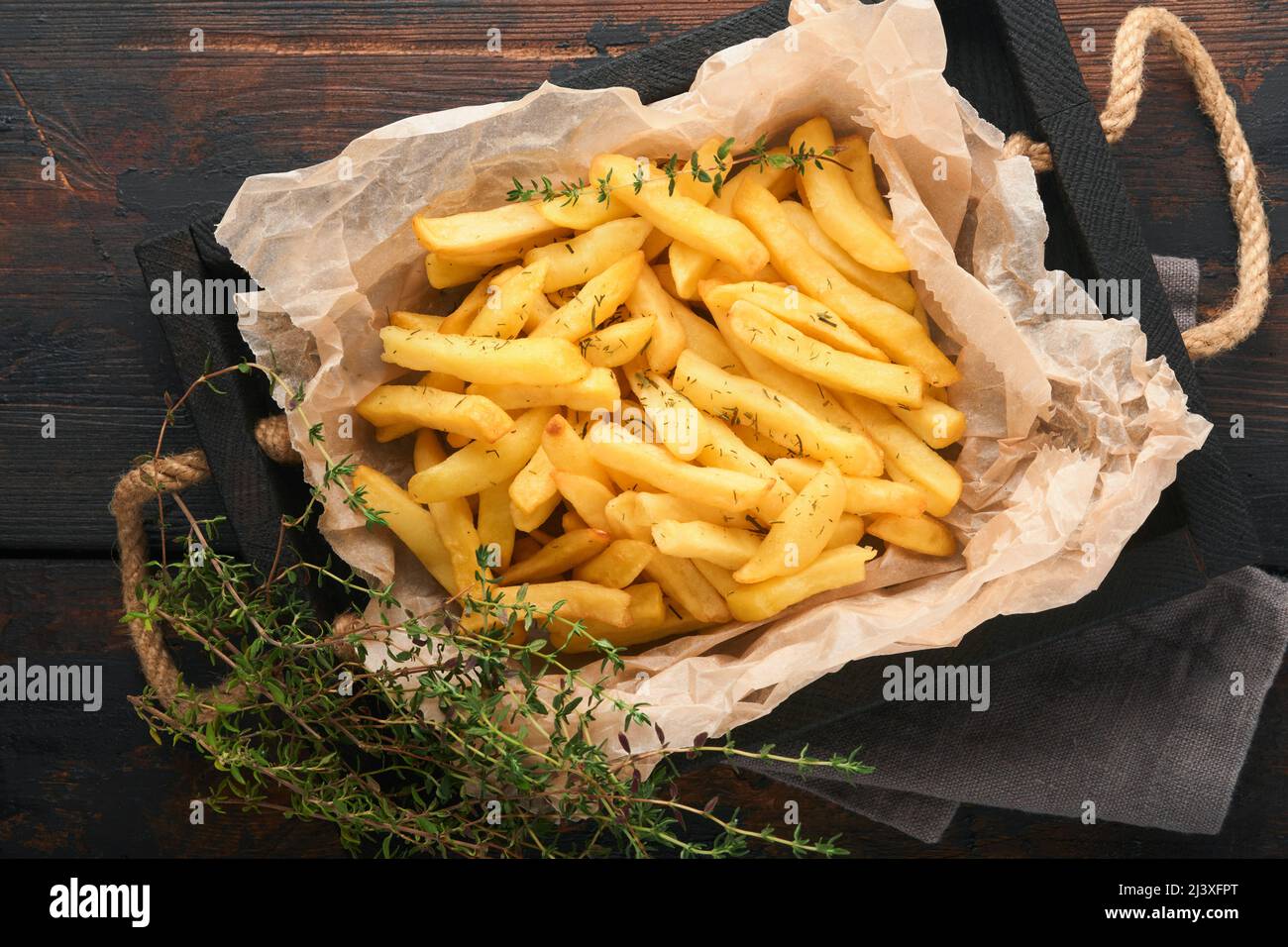 French fries. Tasty French fries server on parchment paper on wooden ...