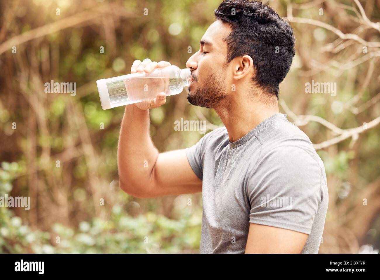 Fuel your fitness with hydration. Shot of a fit young man drinking ...