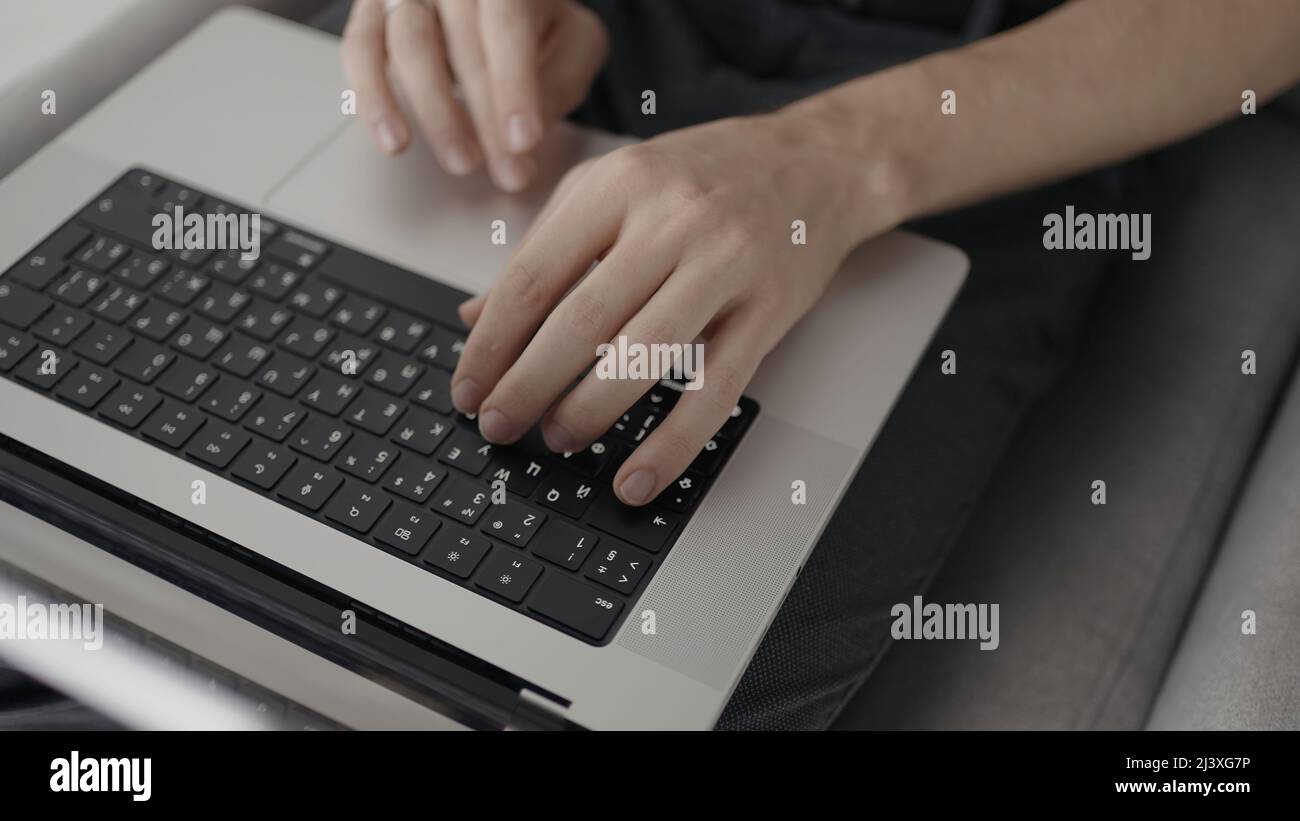 Laptop keyboard. Action. A person sits at a computer and works in ...