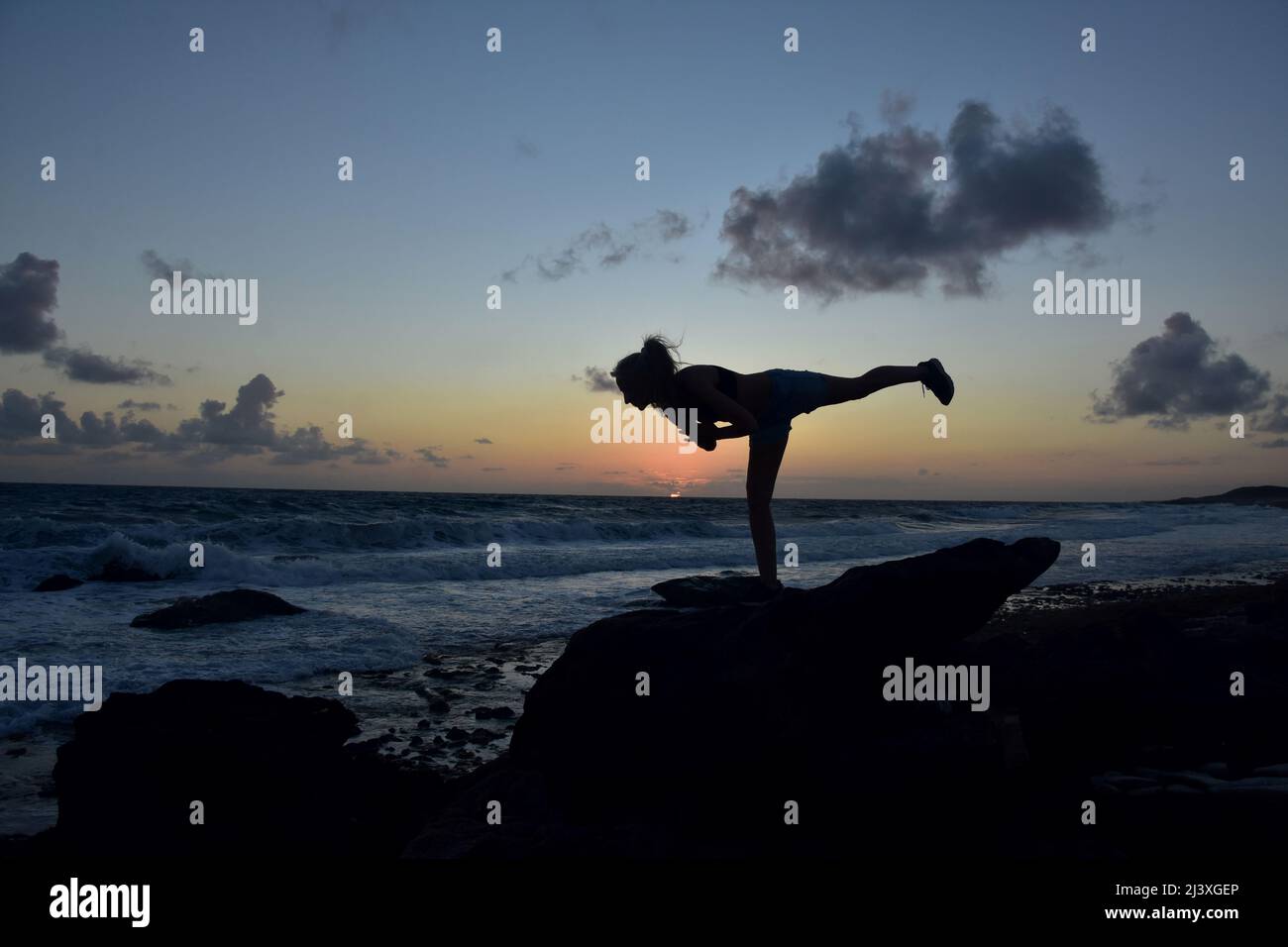 Warrior 3 yoga balance pose with sun rising over the ocean Stock Photo ...