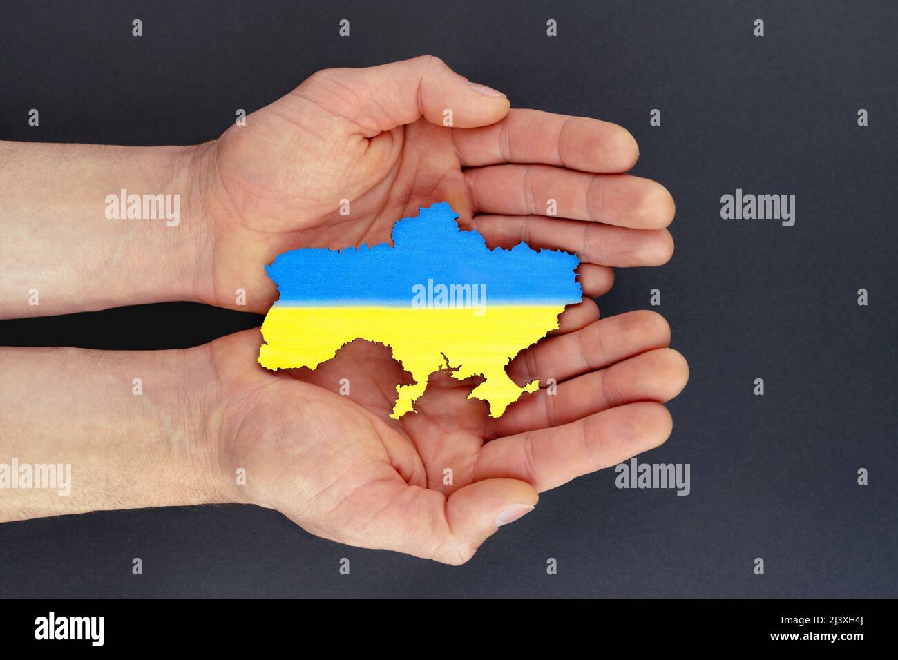 Top view of male hands hold map of Ukraine on black background. Concept ...