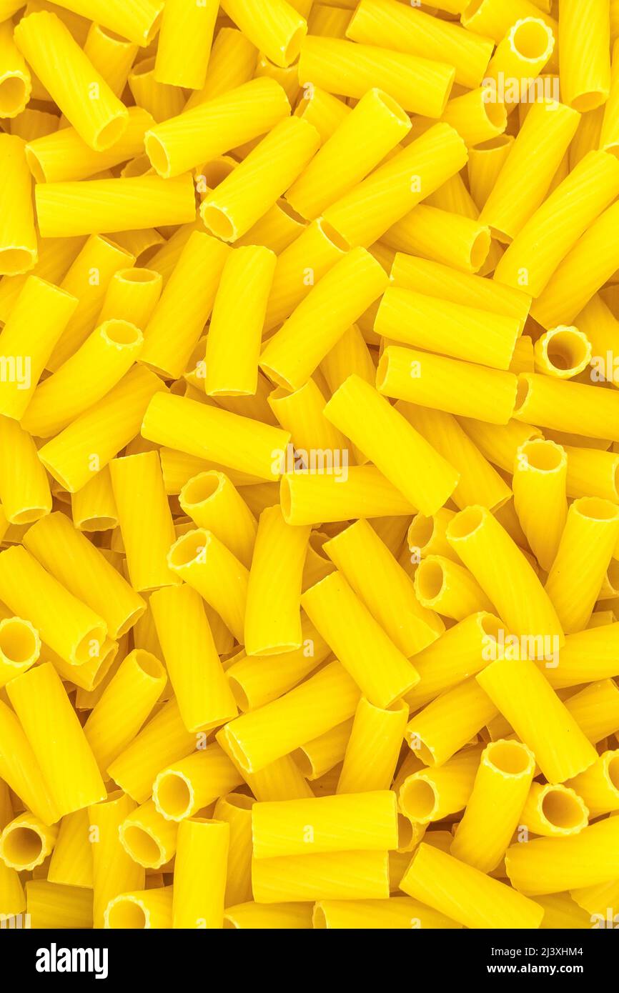 Uncooked short pasta tubes, elicoidali in food basket, background and ...