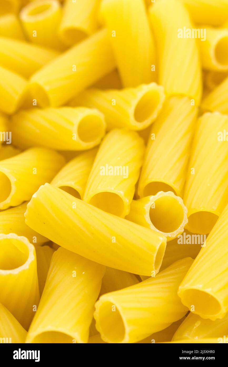Uncooked short pasta tubes, elicoidali in food basket, background and ...