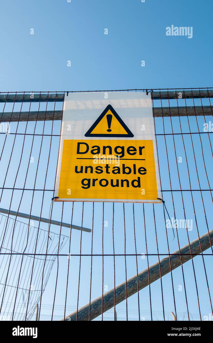 Danger unstable ground sign on a fence against a blue sky Stock Photo ...