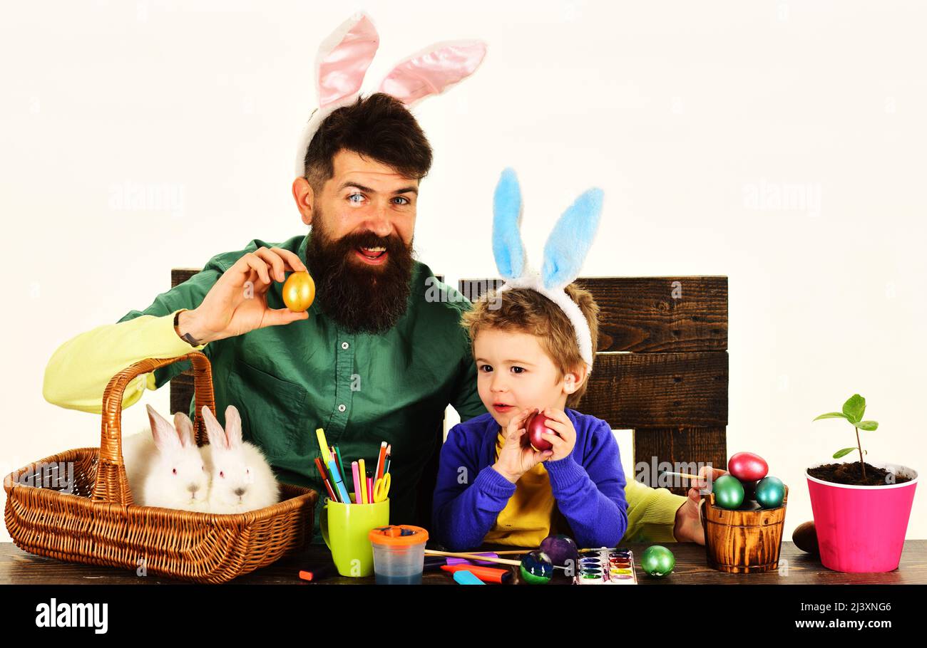 Father and son painting eggs. Happy Family preparing for Easter holiday ...