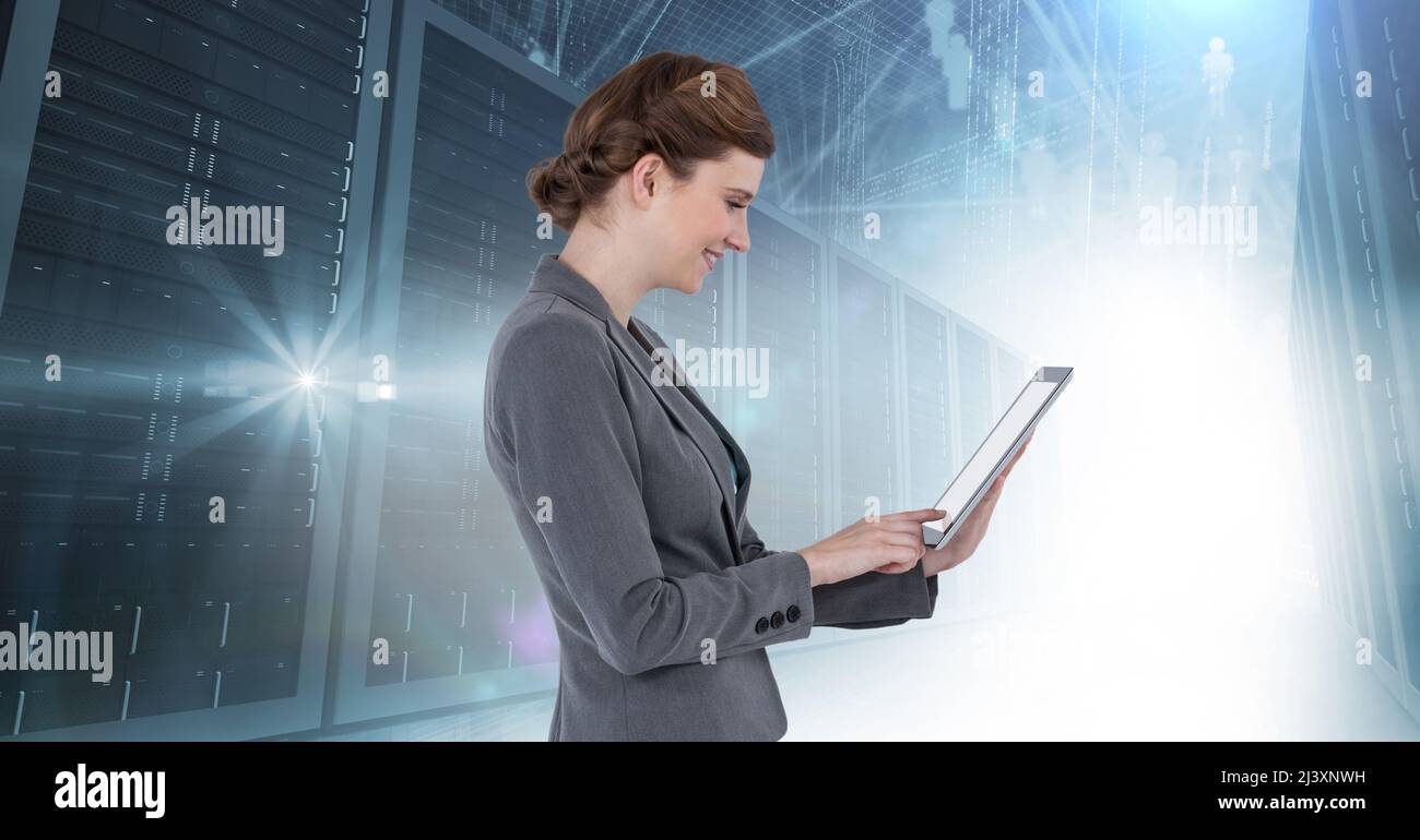 Caucasian businesswoman using digital tablet against spot of light and ...