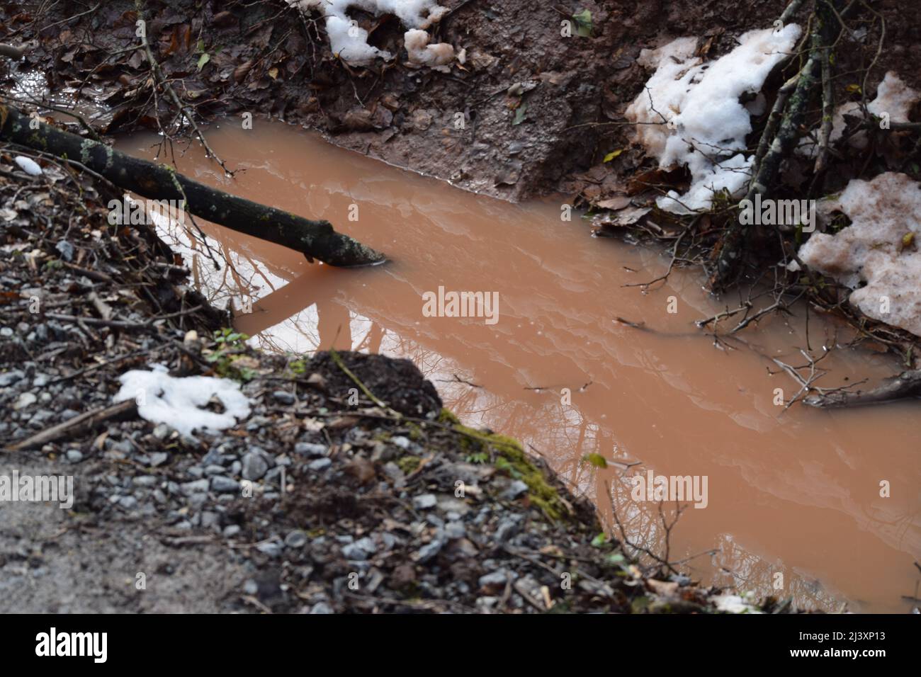 Puddle contaminated by red Soil Stock Photo - Alamy