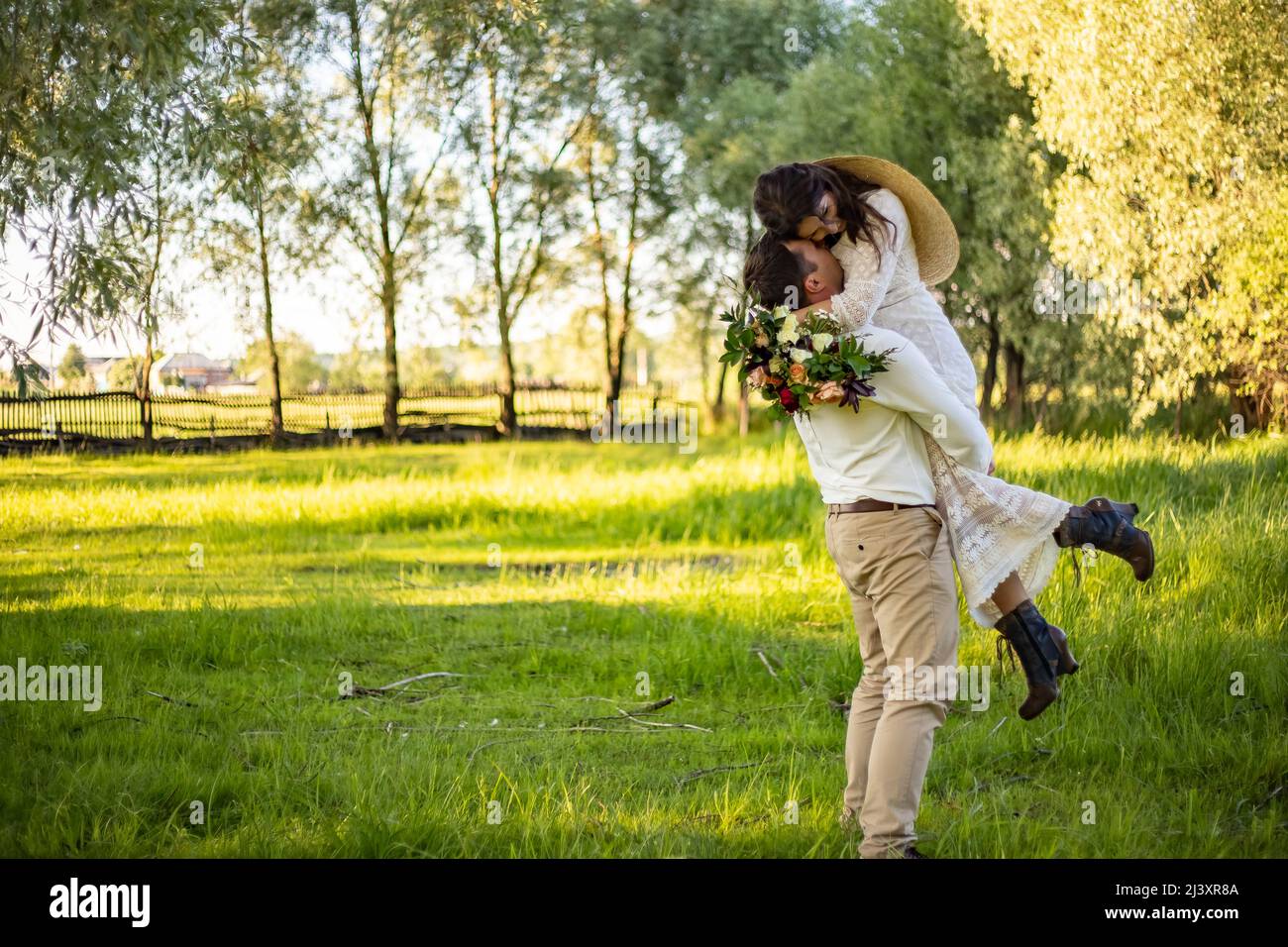Stylish happy bride, groom hold picked up in hands and dancing. The ...