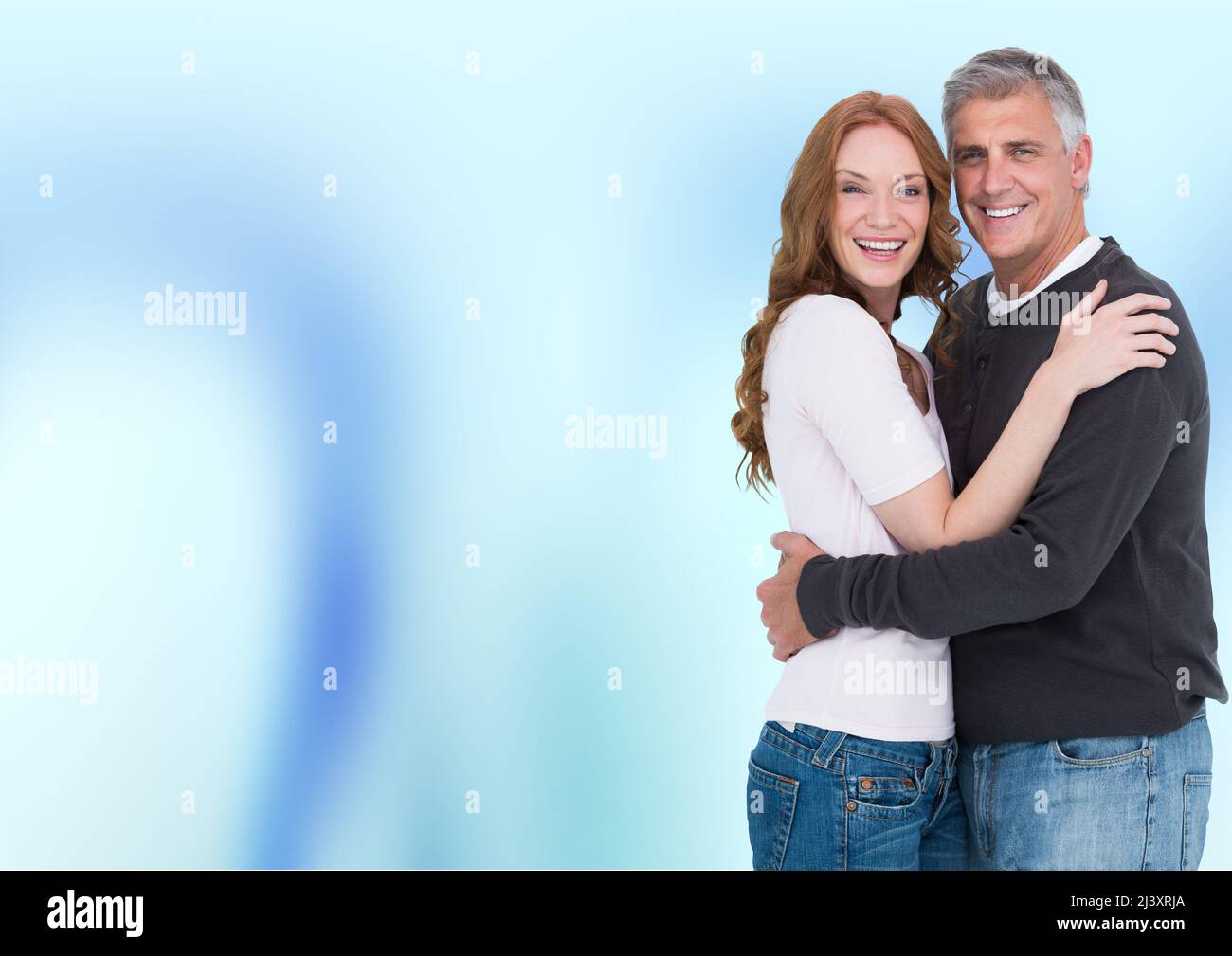 Portrait of caucasian senior couple hugging against copy space on blue ...