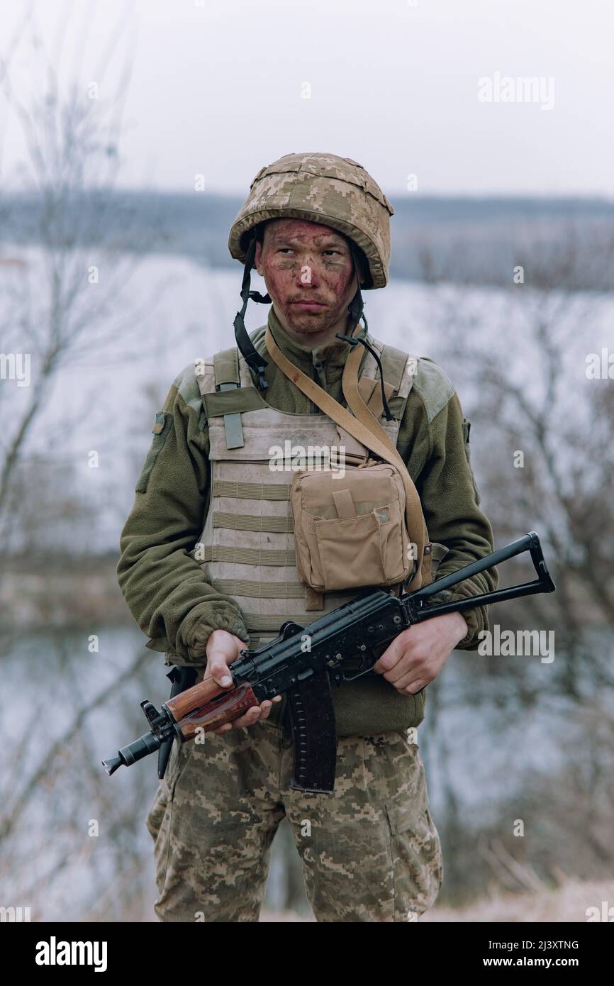 Ukrainian soldier stands with kalashnikov assault rifle in his hands ...