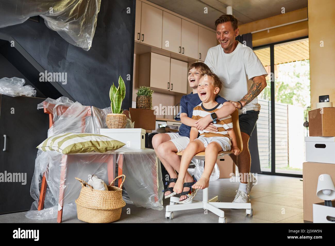 Full length portrait of happy family moving into new house with ...