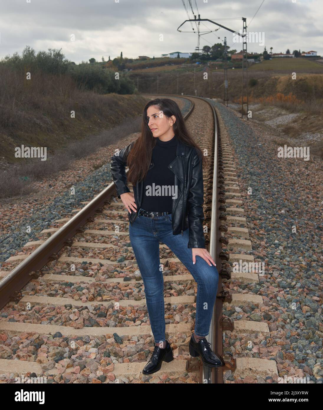 A pretty girl posing quietly on train rails Stock Photo - Alamy