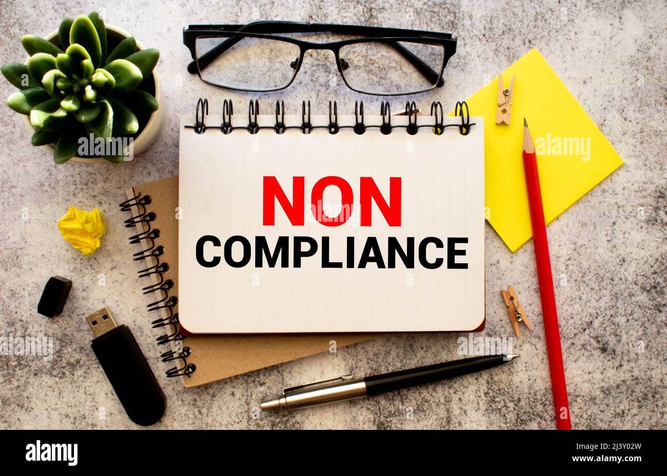 Closeup on businessman holding a card with NON COMPLIANCE message ...