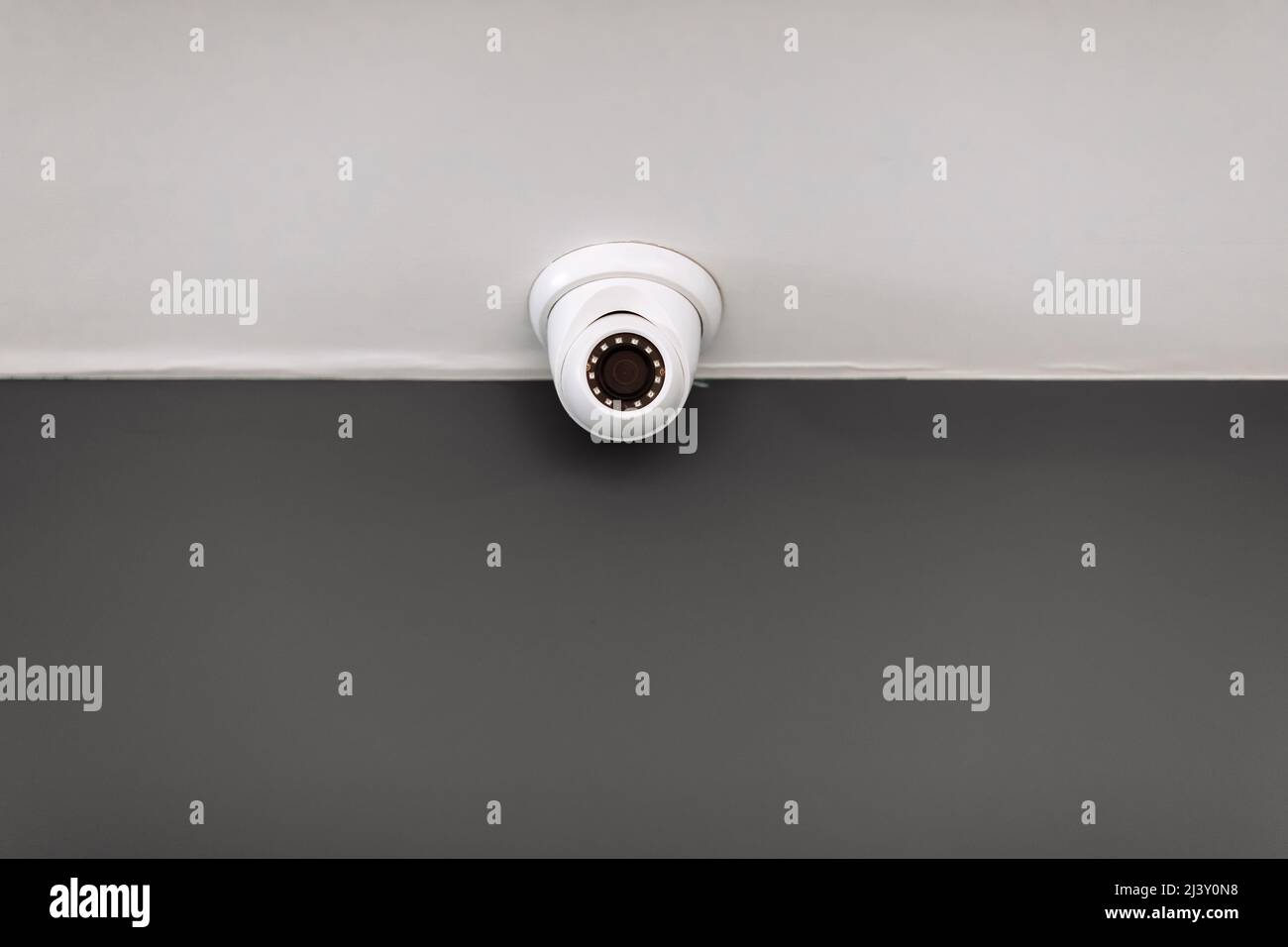 White security CCTV Camera or surveillance operating on ceiling inside ...