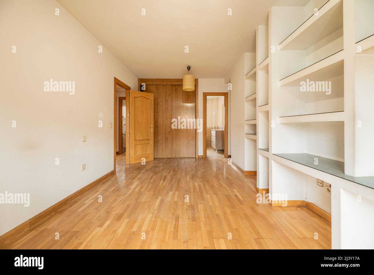 empty room with plaster shelf with glass shelves and access to a toilet ...
