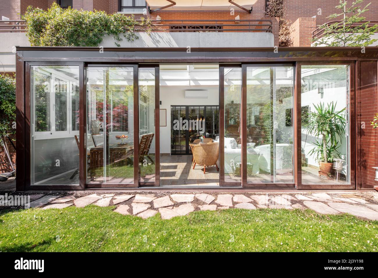 Glass and brown aluminum covered terrace at the bottom of a residential ...