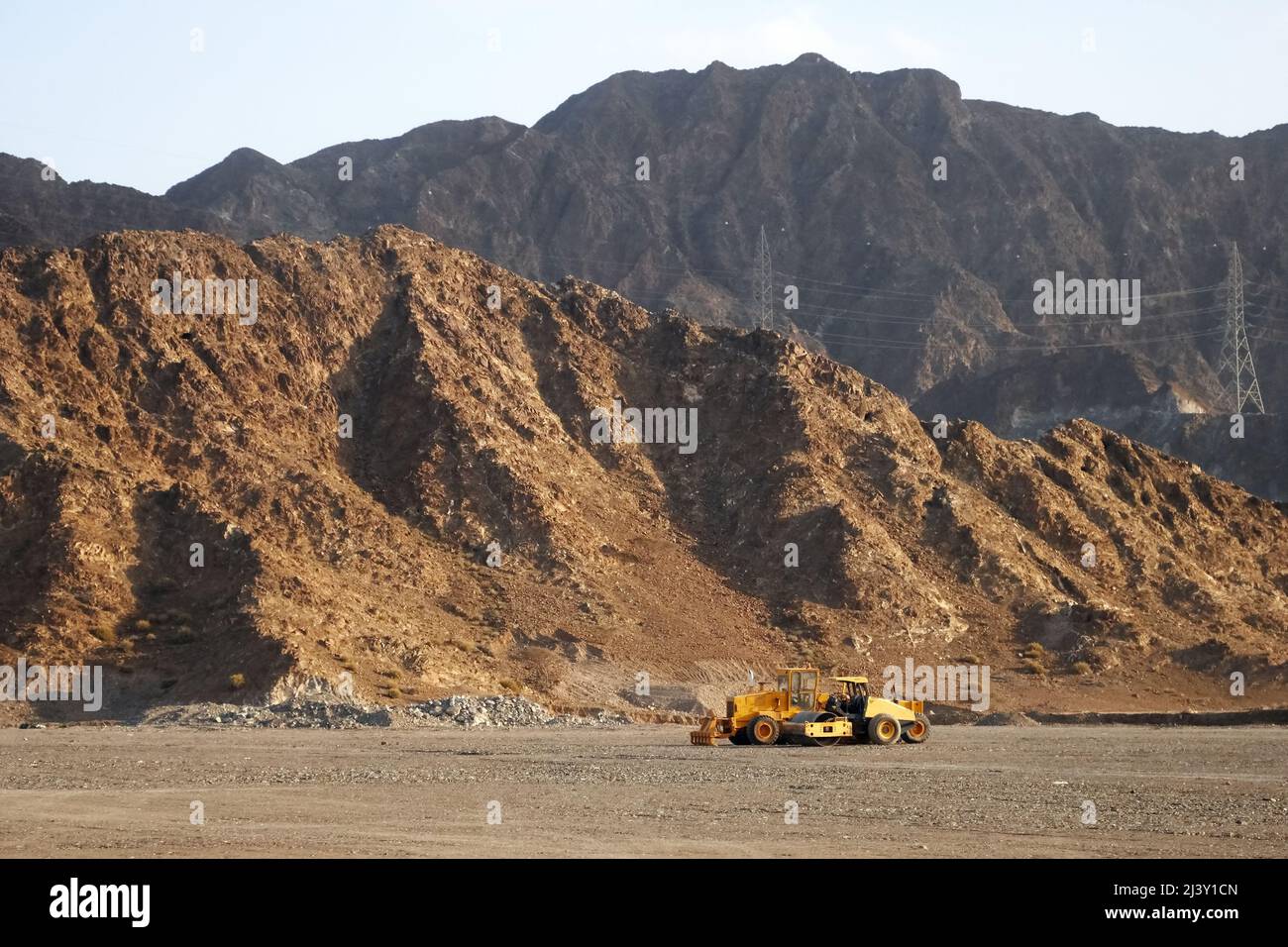 Heavy construction equipment on the square near the brown rocks in the ...
