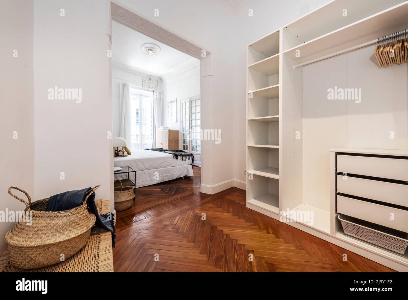 Walk-in closet with white wooden shelving with matching chest of ...