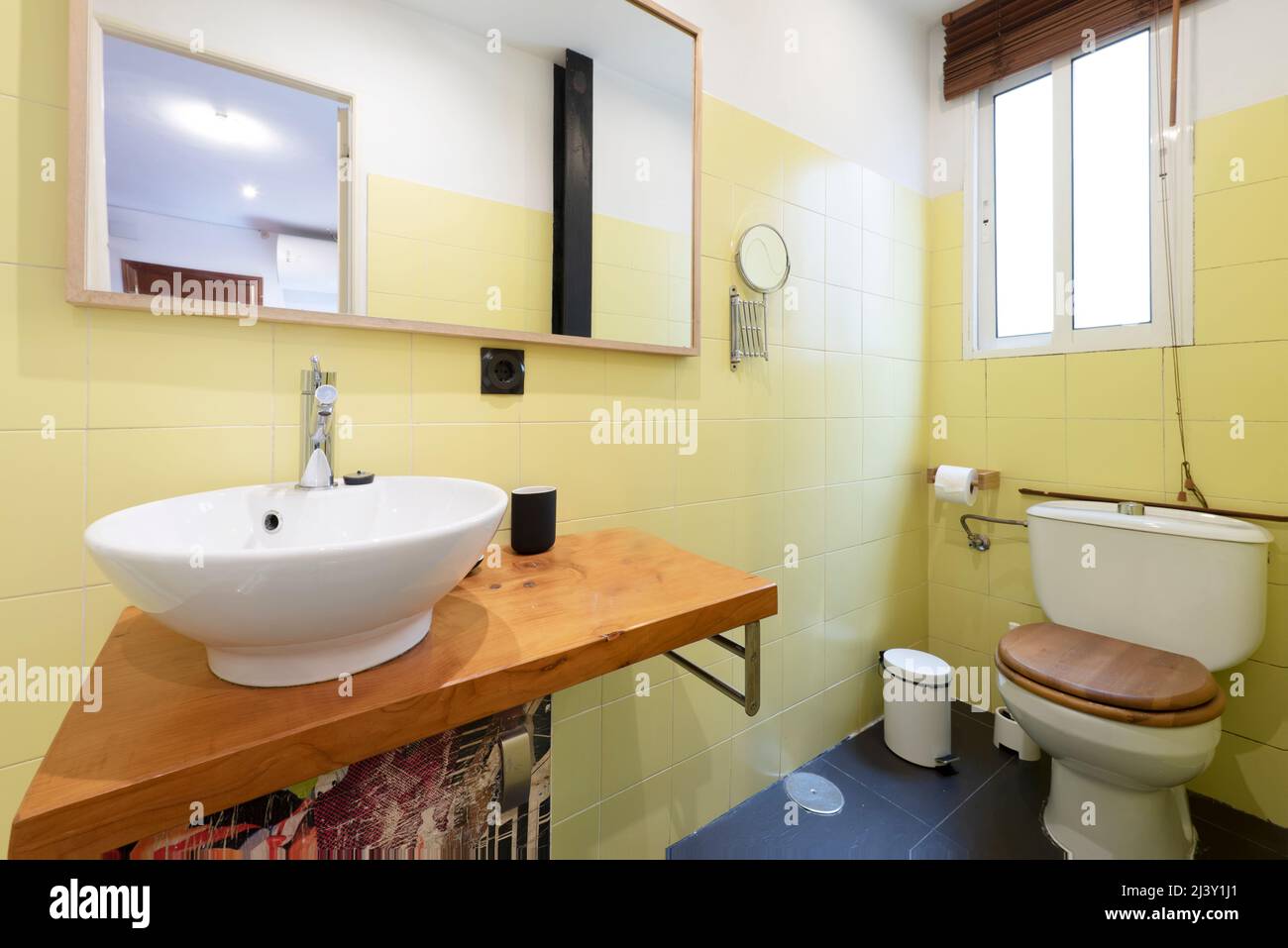 Bathroom with wood-framed mirror, solid wood plank top, white porcelain ...