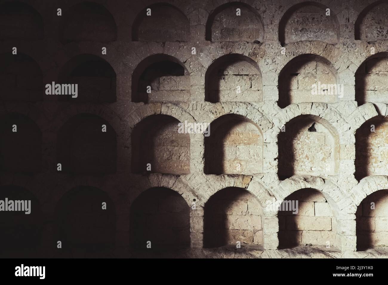 Large arched niches in the ancient stone wall of the cave Stock Photo ...