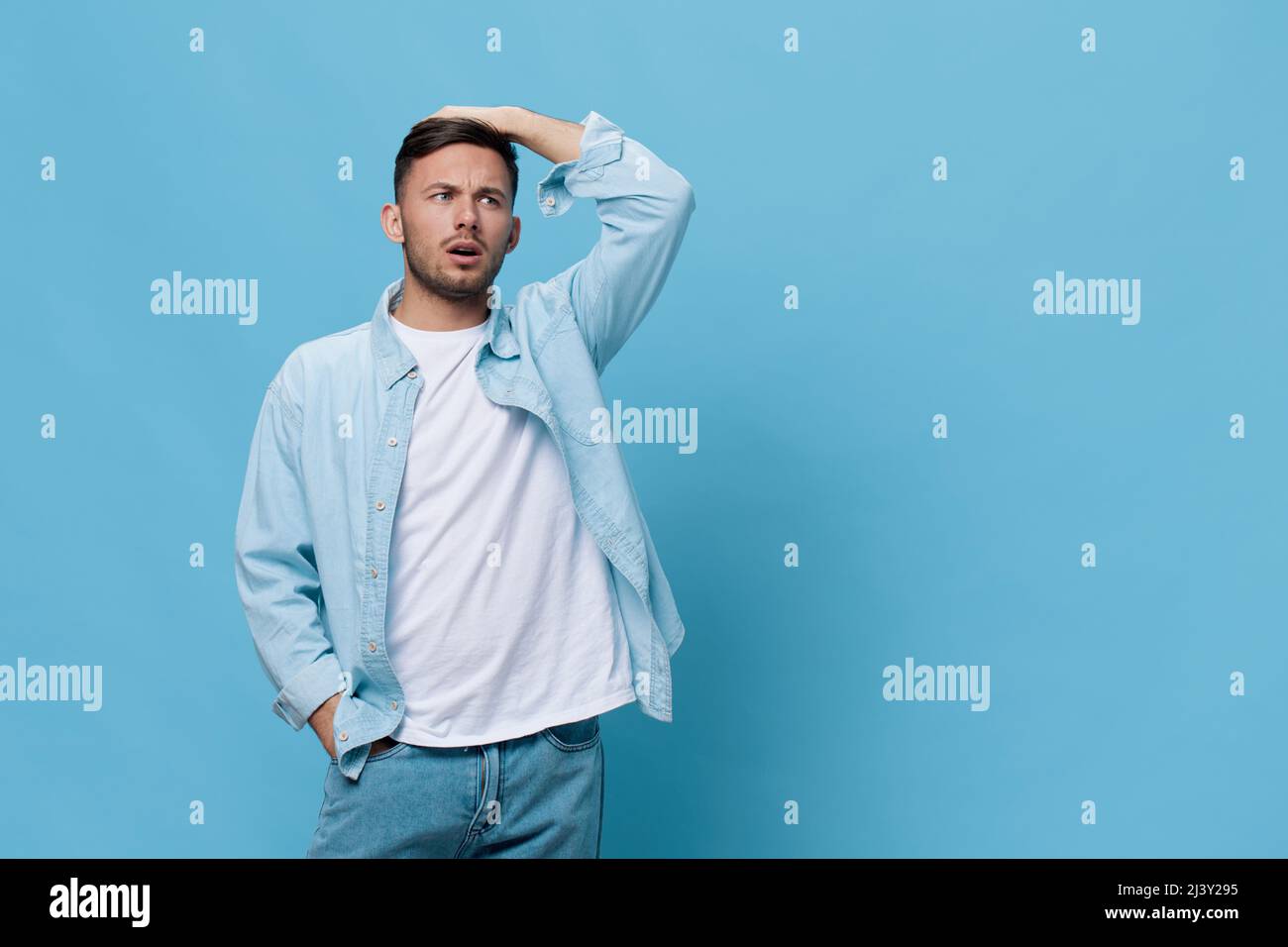 Worried sad unhappy tanned handsome man in casual basic t-shirt touch ...