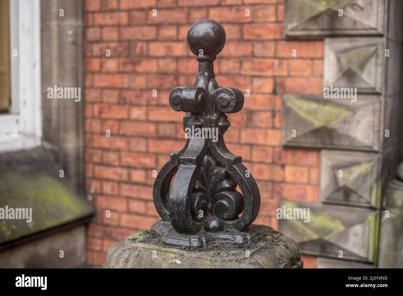 a wrought iron ornamental cap at a stone gate post at a victorian ...