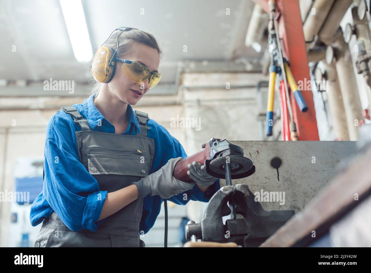 Woman mechanic working with disk grinder Stock Photo - Alamy