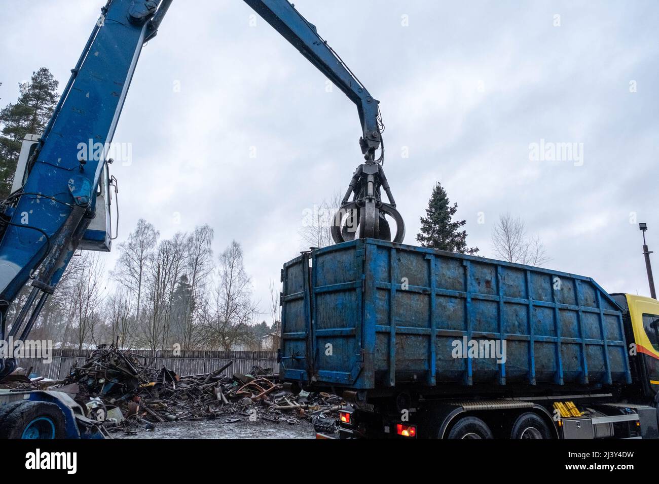 hydraulic grab cleans and tampens metal debris. excavator lifts and ...